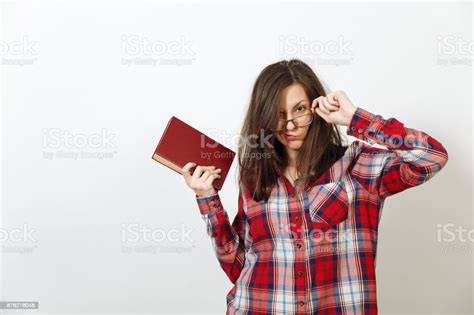 아름 다운 유럽 젊은 금발 여자 캐주얼 붉은 격자 무늬 셔츠 흰색 배경에 책으로 서 입은 건강 한 깨끗 한 피부와 시력에 안경에 독서 하 고 공부 하는 개념입니다 갈색에