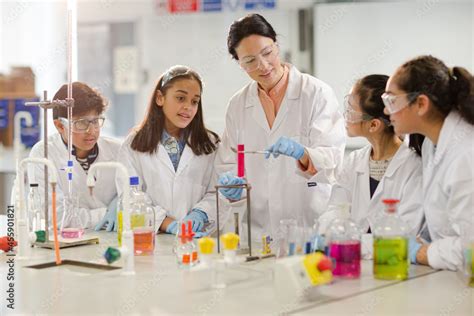 Foto De Female Teacher And Babes Conducting Scientific Experiment Watching Liquid In Test