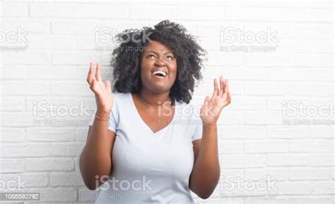 젊은 아프리카계 미국인 플러스 크기 여자 흰 벽돌에 벽 미친 미친 소리 하 고 적극적인 식와 팔 발생 함 좌절 개념입니다 감정에