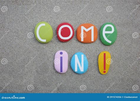 Come In Creative Text Composed With Multi Colored Stone Letters Over Beach Sand Stock