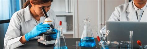 Scientist Conduct Chemical Experiment Using Microscope In Medical Lab
