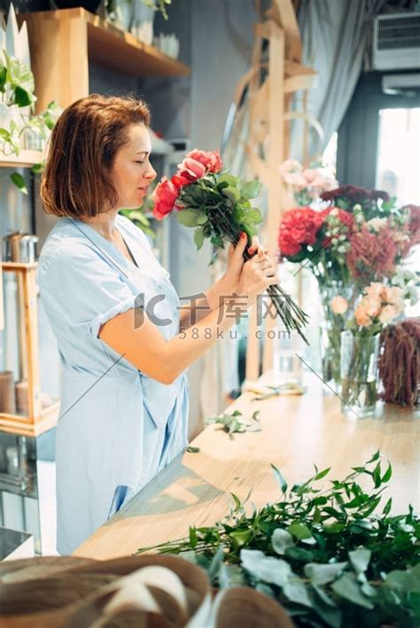 女花店持有新鲜红玫瑰花店。花店生意，花束制作 高清摄影大图 千库网