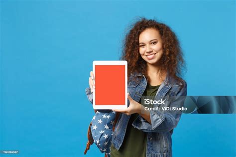 데님 옷 배낭 홀드 패드 Pc 파란색 배경 스튜디오 초상화에 고립에서 젊은 아프리카계 미국인 소녀 십 대 학생 고등학교 대학 대학 개념에서 교육 복사 공간을 모의 합니다