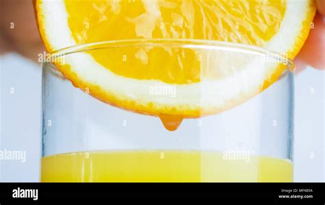 Macro image of hand squeezing orange juice in glass Stock Photo - Alamy