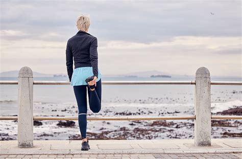 여성의 뒤에서 운동 웰빙 및 훈련을 위해 해변 산책로에서 피트니스와 스트레칭을 합니다 여성 주자 및 사람은 야외 운동 스포츠