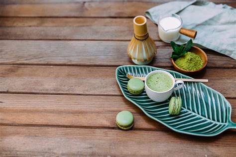 일본 녹색 말차 라떼 말차 가루 오래된 나무 보드에 채찍질대나무 거품기 항산화물질이 풍부한 건강한 유기농 제품인 말차 차 맨 위 보기입니다 요리하기 음식 준비에 대한 스톡