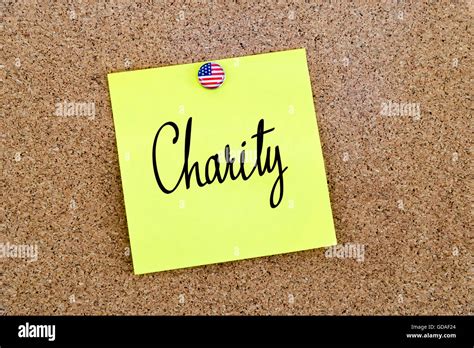 Written Text Charity Over Yellow Paper Note Pinned On Cork Board Stock