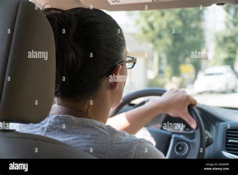 Over The Shoulder Pov Young Woman Driving A Car On A Suburban Street