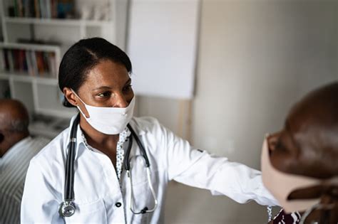 여성 의사는 의료 약속 중에 수석 환자를 위로 얼굴 마스크를 사용하여 2명에 대한 스톡 사진 및 기타 이미지 2명 70