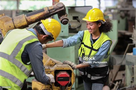지능형 공장 자동차에서 고장난 로봇 팔 기계의 안전 작업복 수리 부품에 있는 전문 중공업 기술자 엔지니어 그룹 산업 및 기술