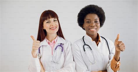 의료 지원 보험 건강 관리 및 의학 개념 두 명의 다인종 전문 여성 의사가 병원 사무실에서 엄지손가락을 치켜들고 팀으로 서서 카메라를 향해 웃고 있다 사진