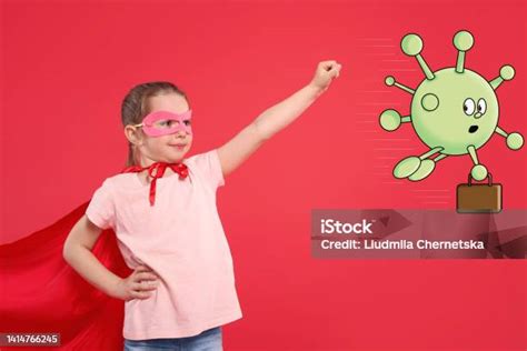 슈퍼 히어로 의상을 입은 어린 소녀가 빨간 배경에서 바이러스와의 싸움에서 승리했습니다 빨강에 대한 스톡 사진 및 기타 이미지