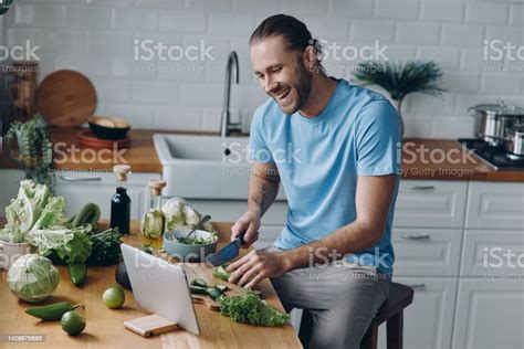 국내 부엌에서 음식을 준비하면서 디지털 태블릿을보고 행복한 청년 가사 집안일에 대한 스톡 사진 및 기타 이미지 가사 집안일 가정 생활 가정 주방 Istock