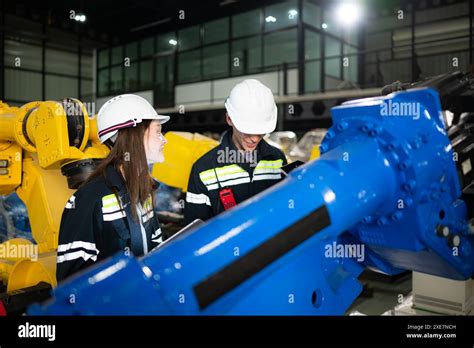 Both Of Engineers Working Together In A Robotic Arm Factory Robotic