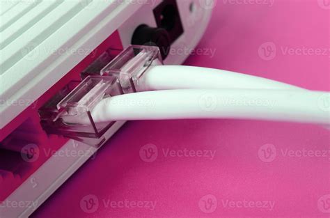 The Internet Cable Plugs Are Connected To The Internet Router Which Lies On A Bright Pink