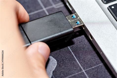 Hand Inserting Hardware Wallet Plugged Into A Computer Laptop Hand