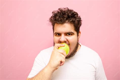 Premium Photo Portrait Of A Funny Bearded Fat Man Biting An Apple On