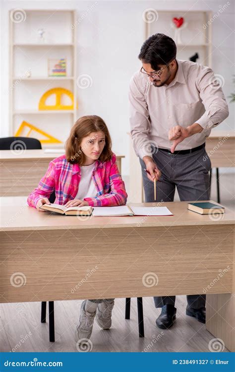 Young Male Teacher And Redhead Girl In The Classroom Stock Image