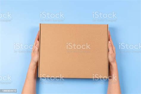 밝은 파란색 배경에 갈색 판지 상자를 들고있는 여성의 손의 상단보기 모형 소포 상자 포장 쇼핑 배달 개념 판지 상자에 대한 스톡 사진 및 기타 이미지 Istock