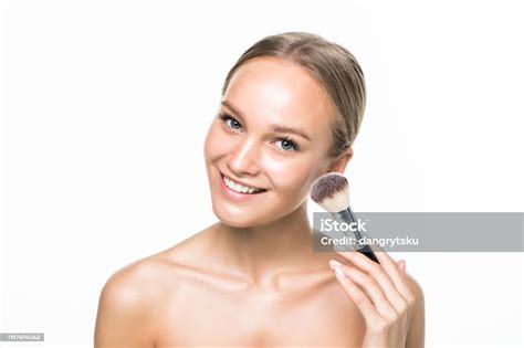 흰색 배경 위에 고립 된 브러시로 느슨한 얼굴 파우더를 적용하는 아름다운 젊은 여성 공간을 복사합니다 그늘에 대한 스톡 사진 및