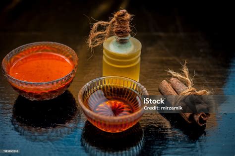 계피 분말 꿀 올리브 오일 헤어 마스크는 금빛이 분리 된 나무 표면에 유리 그릇에 원시 계피 스틱 꿀 및 올리브 오일과 함께 표면에 존재합니다 수평 샷 Mahal