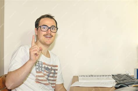 Premium Photo Young Man With Nerdstyle Glasses Having Idea Pointing His Finger Up