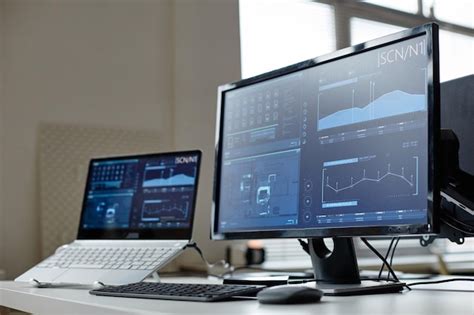 Premium Photo Computers On Desk With Data Screens