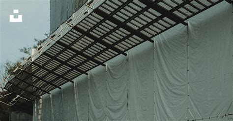 흰색 긴 소매 셔츠와 검은 바지를 입은 여자가 회색 콘크리트 바닥에 서 있다 사진 Unsplash의 무료 건물 이미지