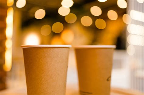 두 개의 골판지 커피 컵을 닫고 보케 배경 복사 공간과 텍스트를 위한 빈 공간 위에 테이블을 가져갑니다 커피숍에서 음료 개념을 가져갑니다 2022년에 대한 스톡 사진 및