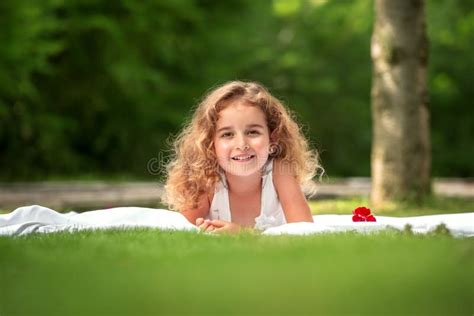 Portret Van Een Glimlachend Meisje Dat Op Groen Gras Ligt Stock Foto