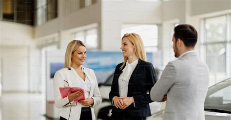 대리점에서 구매자에게 자동차를 판매하는 전문 판매원 사진 Unsplash의 사업 이미지