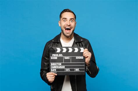 검은 색 자 켓 흰색 T 셔츠에 잘생긴 세련 된 젊은 이루어지지 남자는 파란색 벽 배경 스튜디오 초상화에 고립 된 옷을 만드는 핸드 필름에 개최 사람들 라이프 스타일