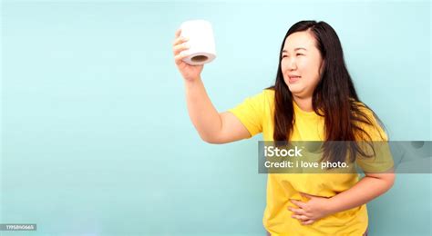 설사 증상을 가진 아시아 여자 스튜디오에서 파란색 배경에 고립 된 설사로 고통받는 아픈 여성 가정의 방에 대한 스톡 사진 및