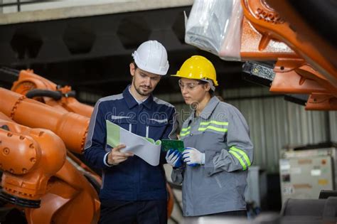 Engineers Working Robot Assembly Industry Plant In Factory Examining