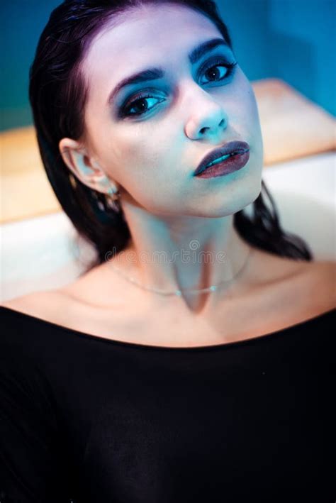 Fille Avec Les épaules Nues Se Situant Dans La Salle De Bains Avec De L eau Pourpre Coloré