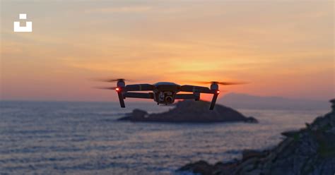 수역 위를 비행하는 카메라가 있는 흰색과 빨간색 드론 사진 Unsplash의 무료 프랑스 이미지