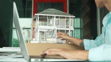 Closeup Of Engineer Using Laptop Analysis House Model Structure