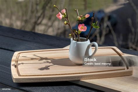 Сutting 보드 너도밤 나무와 자작 나무로 만들어졌으며 작은 크리머에서 일반적인 모과의 꽃이 피는 나뭇 가지로 만들어졌습니다 검은 나무 배경에 0명에 대한 스톡 사진 및