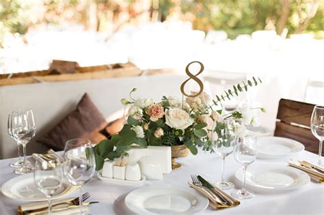 황동 꽃병에 신선한 꽃으로 장식 된 웨딩 테이블 설정 웨딩 플로리스트 녹색 자연을 조망할 수있는 야외 손님을위한 연회 테이블 장미 유스토마 유칼립투스 잎꽃다발 0명에 대한