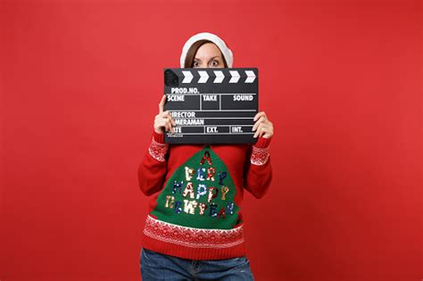 산타 소녀 숨기기 Clapperboard 밝은 빨간색 배경에 절연을 만드는 고전적인 흑인 영화로 얼굴을 덮고 충격 행복 한 새 해 2019 축 하 휴일 파티 개념입니다 복사