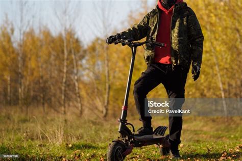 한 젊은이가 가을 숲이나 공원을 통해 전기 스쿠터를 탄다 화창한 가을 날 현대 도시 교통 25 29세에 대한 스톡 사진 및 기타 이미지 Istock