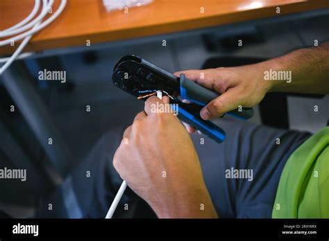 Unrecognizable Hand Cutting Ethernet Network Cable With Tool For Crimping Rj 45 Connectors Stock