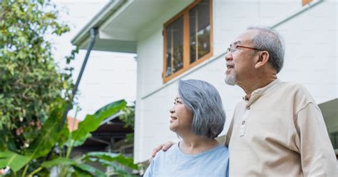 아시아 노인 부부는 집에서 야외에 서서 행복을 느끼고 함께 은퇴 생활을 즐긴다 사랑하는 나이 든 조부모님은 미소를 지으며 서로를 껴안습니다 가정에서의 관계 및 활동 개념