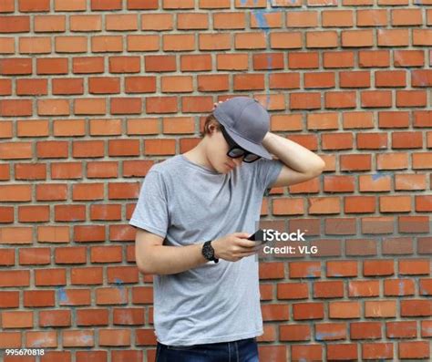 10 대 소년 입력 텍스트 메시지입니다 스마트 휴대 전화를 사용 하 여 가을에 대한 스톡 사진 및 기타 이미지 가을 거리 걷기 Istock