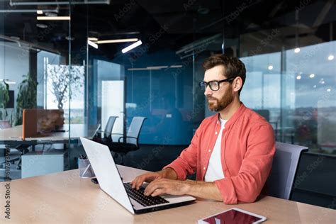 thinking and serious man working with laptop inside office focused