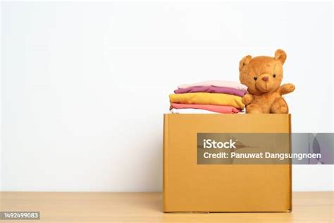 어린이 기부 자선 자원 봉사 기부 및 배달 개념 곰 인형과 옷을 집에 있는 골판지 상자에 직접 기부하여 가난하고 난민 노숙자를 돕고 지원하세요 텍스트 공간 복사 0명에 대한