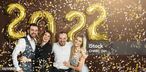 황금 풍선과 떨어지는 색종이와 함께 2022 년 새해의 도착을 축하하는 파티 사람들 2022년에 대한 스톡 사진 및 기타 이미지 2022년 새해 파티 Istock