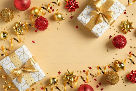 크리스마스 구성입니다 반짝이는 크리스마스 장식 선물 상자 빨간색과 황금색 공 노란색 배경에 색종이로 만든 프레임 플랫 레이 평면도 시즌 인사말 카드 모형 사진