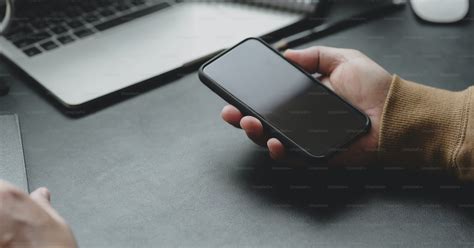 어두운 현대적인 사무실에서 스마트폰을 들고 있는 전문 사업가의 자른 샷 사진 Unsplash의 태국 이미지