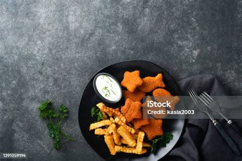 피쉬 칩스 영국 패스트 푸드 검은 테이블 배경에 검은 접시에 감자 튀김이 놓인 생선 스틱 전통적인 영국 정통 거리 음식 또는 테이크 아웃 음식 텍스트를위한 공간으로